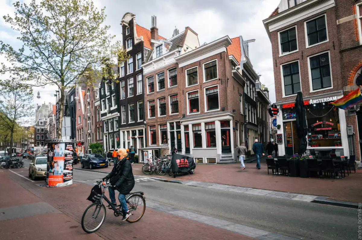 Yetkin qadın, Amsterdam, Hollandiyanın Red Light rayonunda velosiped sürür