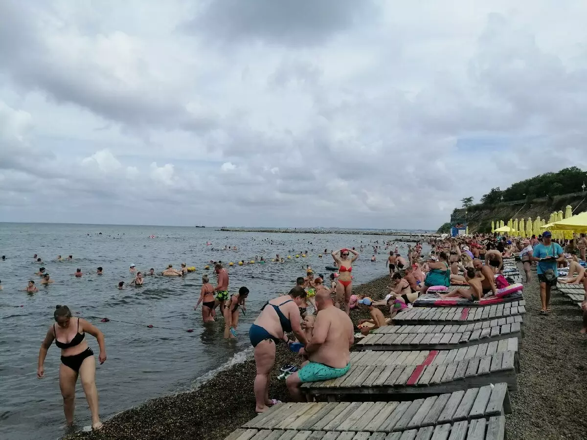 Til høyre viser strandmedarbeider som ser på ingen å bruke gratis solsenger.