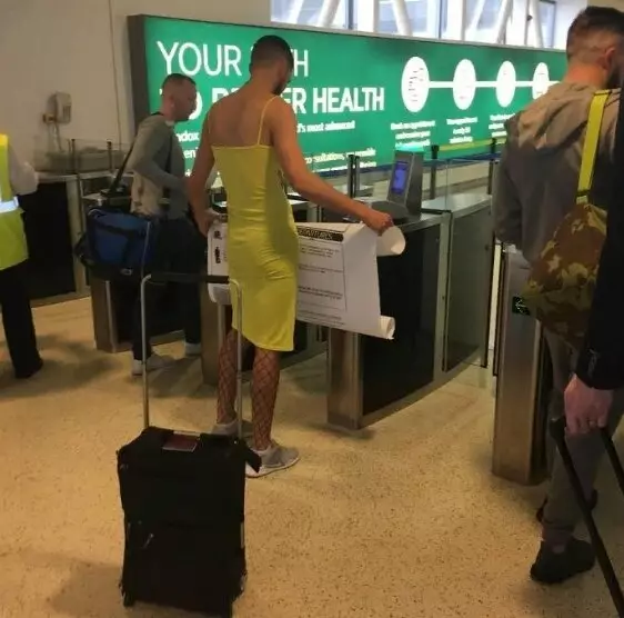 Yes, this is a guy in a dress and mesh pantyhose, and yes, he has a giant air ticket ticket