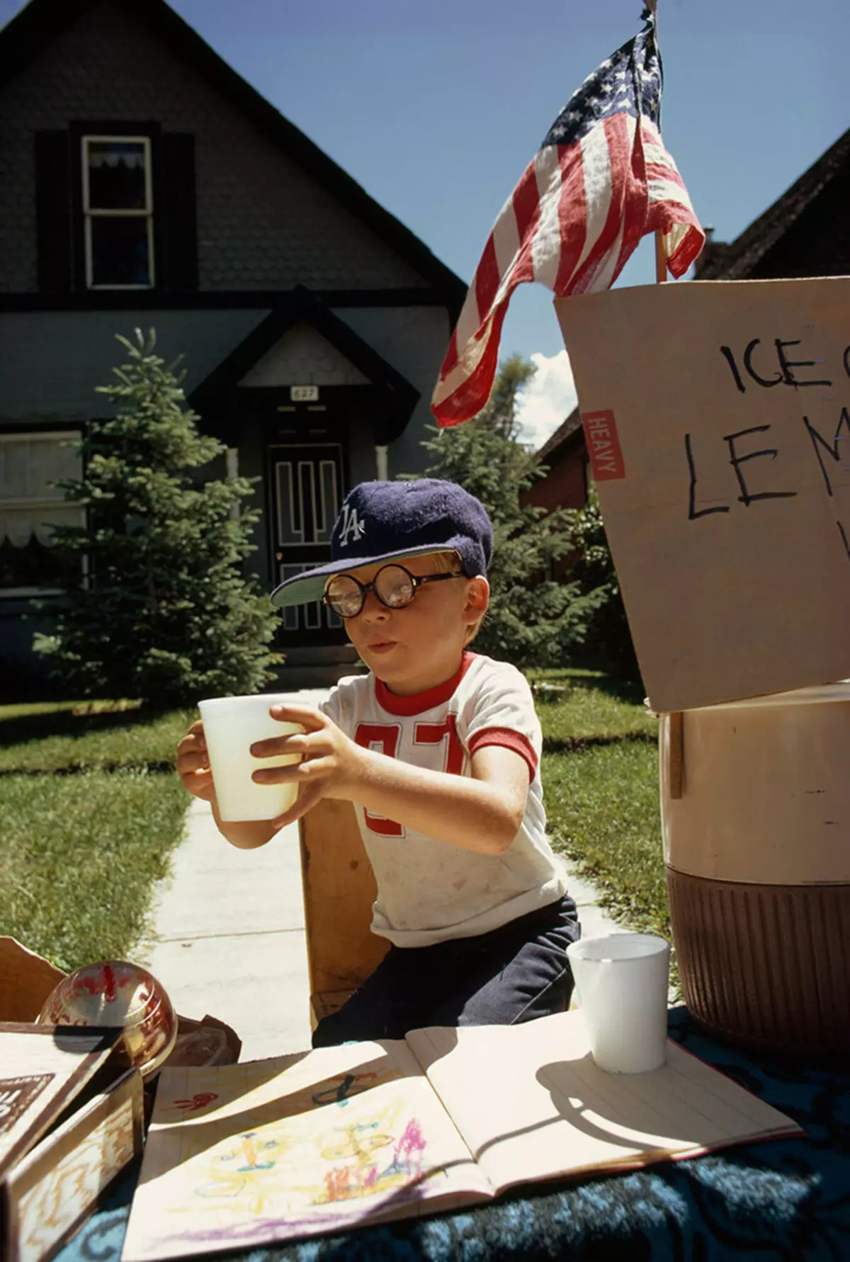 31. La knabo vendas limonadon antaŭ sia hejmo sur la ĉefa strato en Aspen. Kolorado, 1973 Nacia Geografia, Historio, Naturo, Foto